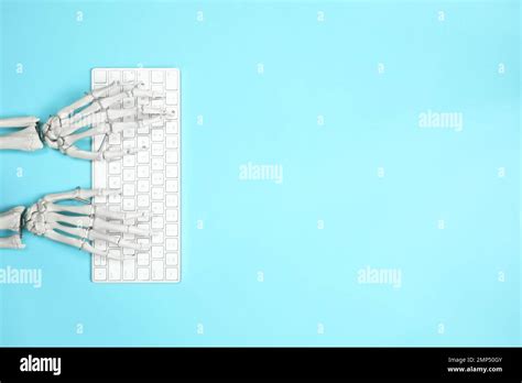 Human Skeleton Using Computer Keyboard On Light Blue Background Top