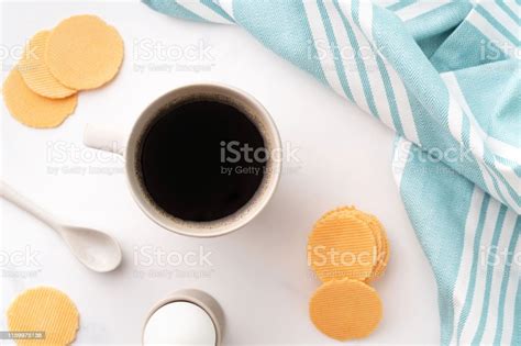세라믹 달걀 컵에 삶은 달걀의 상단보기 커피 한 잔과 아름다운 흰색 모란의 배경에 얇은 바삭한 옥수수 칩 아침 식사 개념입니다