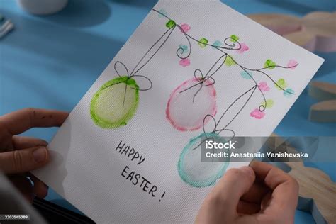 아름다운 필체로 쓰여진 메시지 Happy Easter가 적힌 손수 만든 인사말을 들고 있는 사람 제스처는 다가오는 이벤트에 대한 흥분과 기쁨을 보여줍니다 봄철 휴일 선물