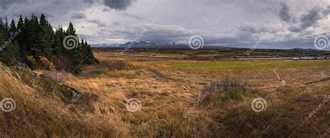 An Empty Grassy Field Is Shown With The Mountains In The Background