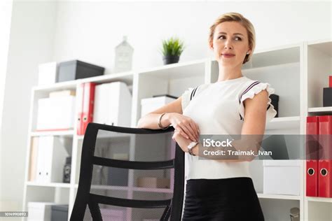 젊은 금발 여 자가의 자의 뒷면에 그녀의 손으로 문서 선반 옆 사무실에서 서 있다 가냘픈에 대한 스톡 사진 및 기타 이미지 가냘픈 감독 개념 Istock