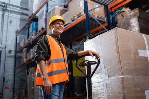 Trabajador De Almacén De Mediana Edad Feliz En Sombrero Duro Y Chaleco