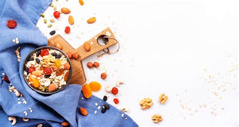 뮤즐리 그릇과 유기농 재료로 건강에 좋은 아침 식사를 제공합니다 그래놀라 견과류 말린 과일 오트밀 흰색 테이블에 통곡물 플레이크 호박 조롱박과 식물에 대한 스톡 사진 및