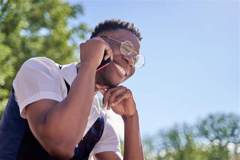 Premium Photo Young African American Man Laughs While Talking On The
