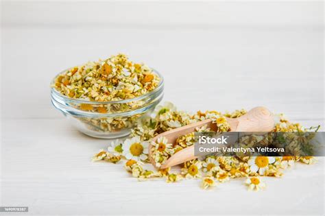 질감 테이블에 말린 카모마일 차드라이 카모마일 카모마일 차 평평하게 누워 박격포에 꽃다발과 카모마일 꽃이 핌이있는 구성 초본