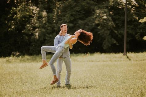 Feliz Pareja Joven Enamorada En El Campo De Hierba Foto Premium