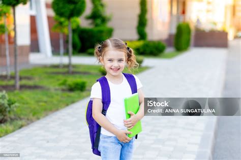 학교로 돌아가면 배낭과 책을 손에 들고 있는 여학생이 초등학교 1학년 때 공부를 하게 됩니다 12 13세에 대한 스톡 사진 및 기타 이미지 Istock