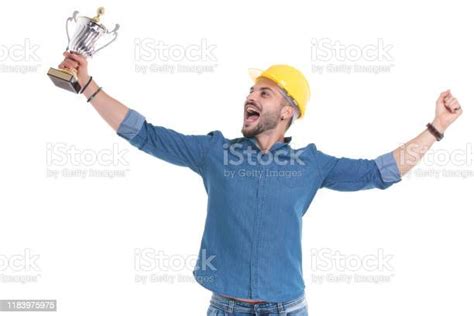 트로피를 들고 축하하고 외치는 성공적인 캐주얼 남자 공사장 인부에 대한 스톡 사진 및 기타 이미지 공사장 인부 팔 들기