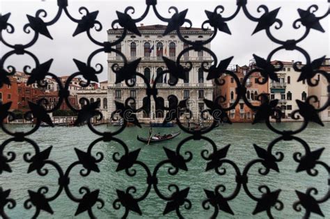A Wrought Iron Fence With A Circle Pattern Overlooks The Water Stock