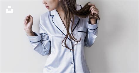 흰색과 검은색 버튼 업 코트를 입은 여자가 벽에 기대어 있습니다 사진 Unsplash의 무료 소녀 이미지