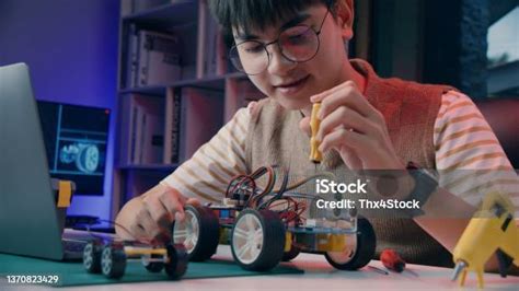 วัยรุ่นเอเชียทําโครงการการบ้านหุ่นยนต์ Arduino ในบ้าน ภาพสต็อก ดาวน์โหลดรูปภาพตอนนี้ Istock