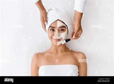 A Beautiful Eastern Woman Enjoys A Rejuvenating Facial Treatment Stock Photo Alamy