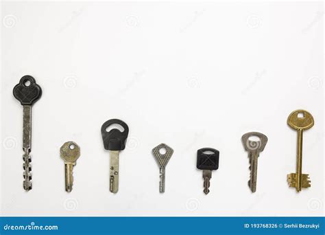 Seven Types Of Different Door Keys Lie In A Row On A White Background Under Clipping Stock Photo