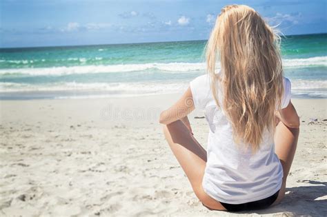 De Jonge Zitting Van De Blondevrouw Op Het Strand Stock Afbeelding