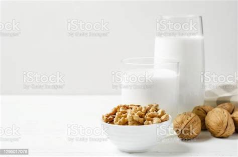 하얀 나무 배경에 호두와 견과류에서 우유 식물성 단백질 비타민 및 유용한 아미노산을 함유한 제품 공간을 복사합니다 우유에 대한