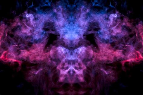 黒い孤立した背景に恐怖の形をしたさまざまな色の煙の抽象的なイメージ、または神秘的な形の魂と幽霊 プレミアム写真