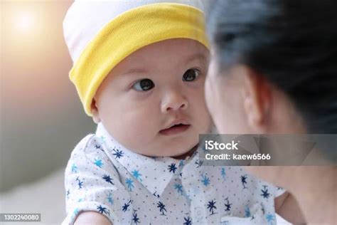 엄마가 집에서 팔에 자신의 포옹하는 동안 그의 어머니를보고 무고한 작은 귀여운 소년 사랑으로 부모를 바라보는 귀여운 어린 시절의