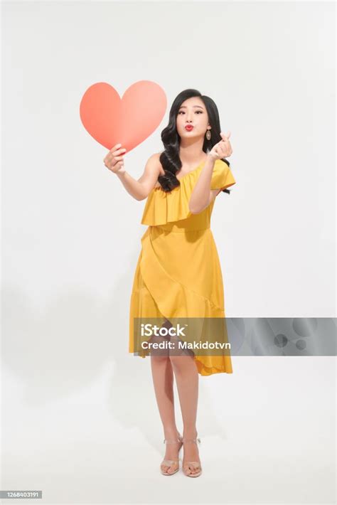 밝은 색상 배경에 고립 된 공기 키스를 보내는 손 큰 종이 심장에 들고 꿈꾸는 소녀 감정에 대한 스톡 사진 및 기타 이미지