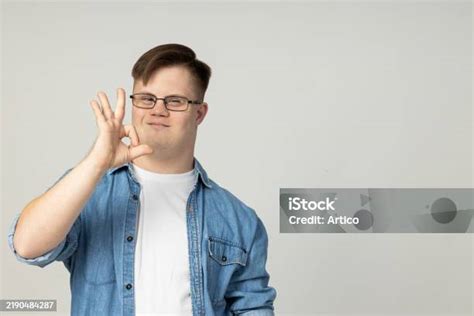 안경과 청바지 흰 티셔츠를 입은 뇌성마비를 앓고 있는 젊은 남성이 카메라를 향해 포즈를 취하고 있다 세계 유전 질환의 날 개념 텍스트 장소 개발에 대한 스톡 사진 및 기타