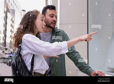 Excited Woman Pointing At Store Window Standing By Man Stock Photo Alamy