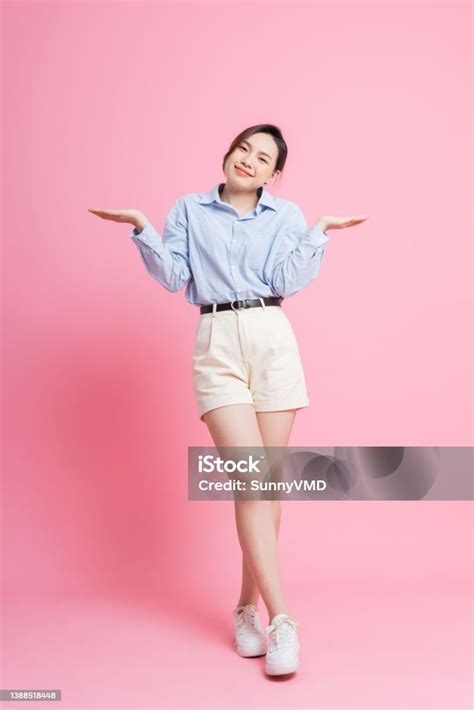 ピンクの背景にポーズをとっているアジアの若い女の子の肖像画 1人のストックフォトや画像を多数ご用意 1人 Full Body