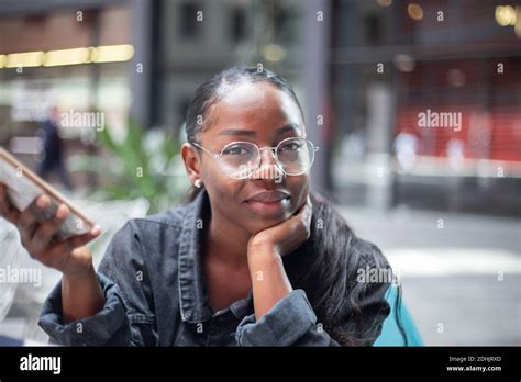 Une femme noire tranquille assise à table avec une tasse de thé et