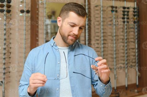 In Optics Shop Portrait Of Male Client Holding And Wearing Different