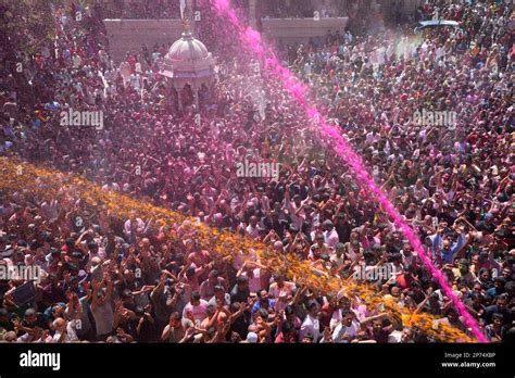 Devotees Cheer As Colored Powder And Water Is Sprayed On Them During