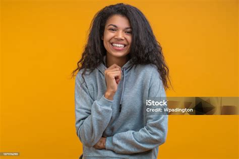 밝은 색상의 노란색 배경 위에 포즈를 취하는 아름다운 행복한 미소 소녀의 스튜디오 초상화 T 셔츠에 대한 스톡 사진 및 기타 이미지 T 셔츠 곱슬 머리 귀여운