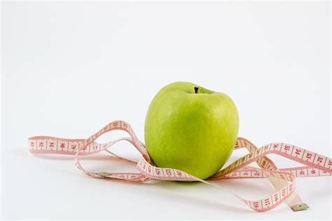 흰색 바탕에 체중 격리 테이프 개념을 측정 하 여 신선한 녹색 사과 0명에 대한 스톡 사진 및 기타 이미지 0명 가냘픈