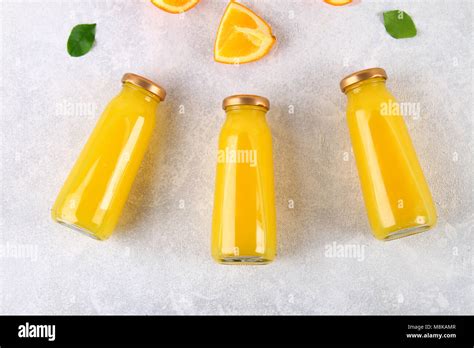 Glass Bottles With Fresh Orange Juice With Orange Slices And Yellow