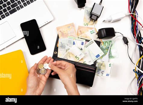 Female Hand Counting Euro Coins From Wallet Near Many Electronic