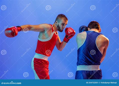 Right Hook Male Professional Boxers In Red And Blue Sports Uniform