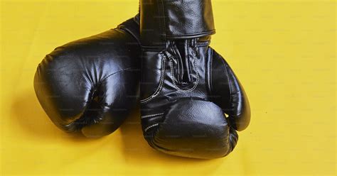 A Pair Of Black Boxing Gloves On A Yellow Background Photo Fight