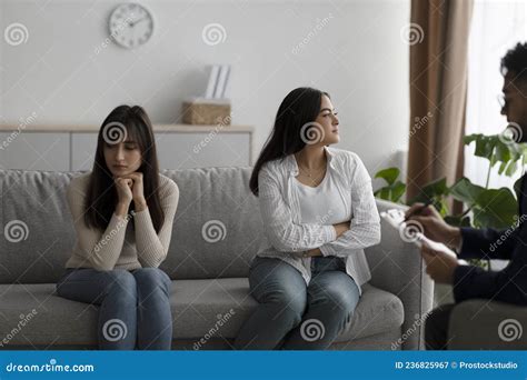 Young Arab Lesbian Couple Having Session With Psychologist Sitting Back To Back At Office