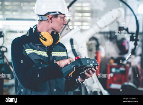 Young Factory Worker Working With Adept Robotic Arm In A Workshop
