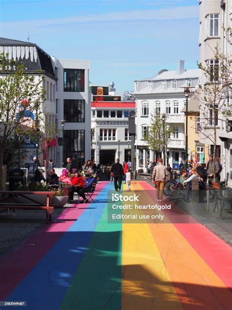 레이캬비크 아이슬란드 2024년 5월 9일 다양성과 포용성을 상징하는 생생한 무지개색 횡단보도가 있는 도시 거리로 사람들이 걷고