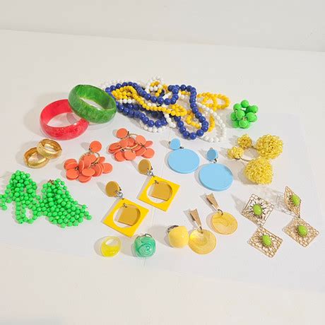 SAMLING AV FÄRGGLADA TALS SMYCKEN I PLAST OCH GULDMETALL Vintagekläder Accessoarer Auctionet