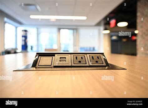 A View Of An Office Area With Black Sockets Light Switch And USB Ports On The Table Stock Photo