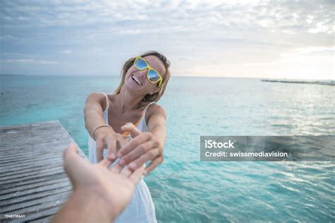 나를 따르라 목 제 부두의 열 대 낙원 해변에 남자 친구를 선도 하는 젊은 여자 2명에 대한 스톡 사진 및 기타 이미지 2명