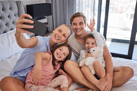 Keluarga Muda Bule Yang Bahagia Duduk Bersama Di Tempat Tidur Dan