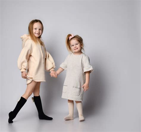 Two Small Beautiful Smiling Girls Sisters In Same Dresses With Stars