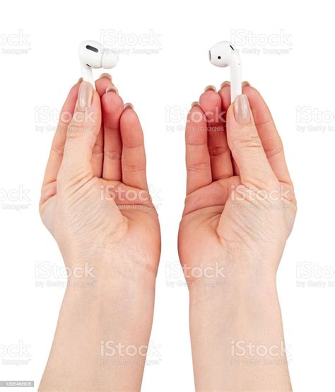 두 명의 여성 손이 흰색 배경에 고립 된 에어포드를 들고 있습니다 여성의 손에 두 가지 유형 흰색 광택 무선 헤드폰 무선 인이어