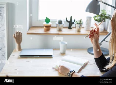 Freelancer Woman With Pencil Taking Notes While Working In Home Office
