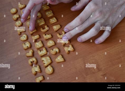 Mens Fingers Typing On The Keyboard Which Is Composed Of Salty Cracker In The Form Of Letters