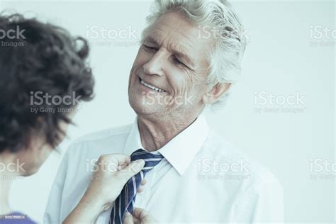 그녀의 쾌활 한 남편의 넥타이 조정 하는 아내 여자 작업에 대 한 준비를 그녀의 남편을 돕는 관계 또는 아침 준비 개념 개인