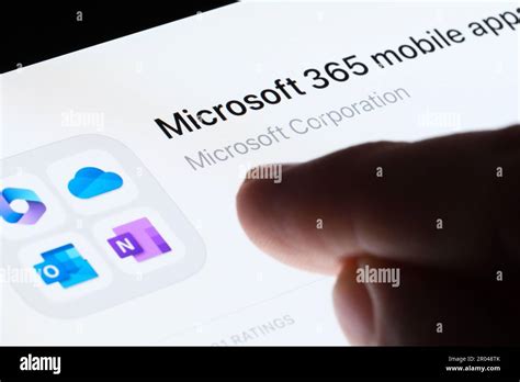 Microsoft 365 Mobile App Seen In App Store On The Screen Of Ipad And Blurred Finger Pointing At