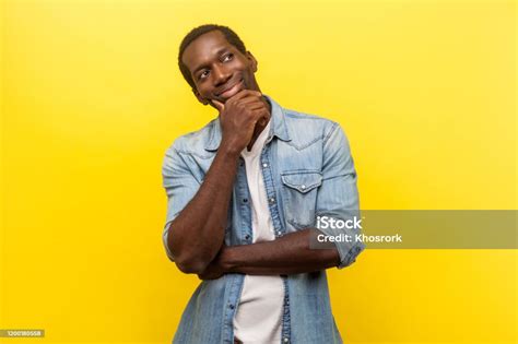 재미 있는 생각을 생각 턱에 손을 잡고 꿈꾸는 쾌활 한 잘 생긴 남자의 초상화 노란색으로 격리 된 실내 스튜디오 샷 남자에 대한