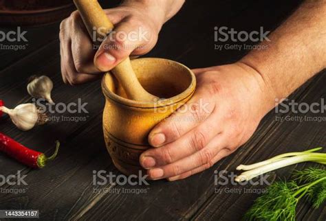 요리사는 나무 유봉과 절구에 혼합 마늘을 으깨고 손에 가까이서 볼 수 있습니다 부엌에서 국가 요리 요리하기 가정 생활에 대한