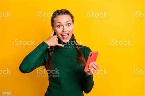 사진 초상화 행복한 여자 표시 전화 나 사인 유지 스마트폰 고립 된 선명한 노란색 색상 배경 갈색 머리에 대한 스톡 사진 및